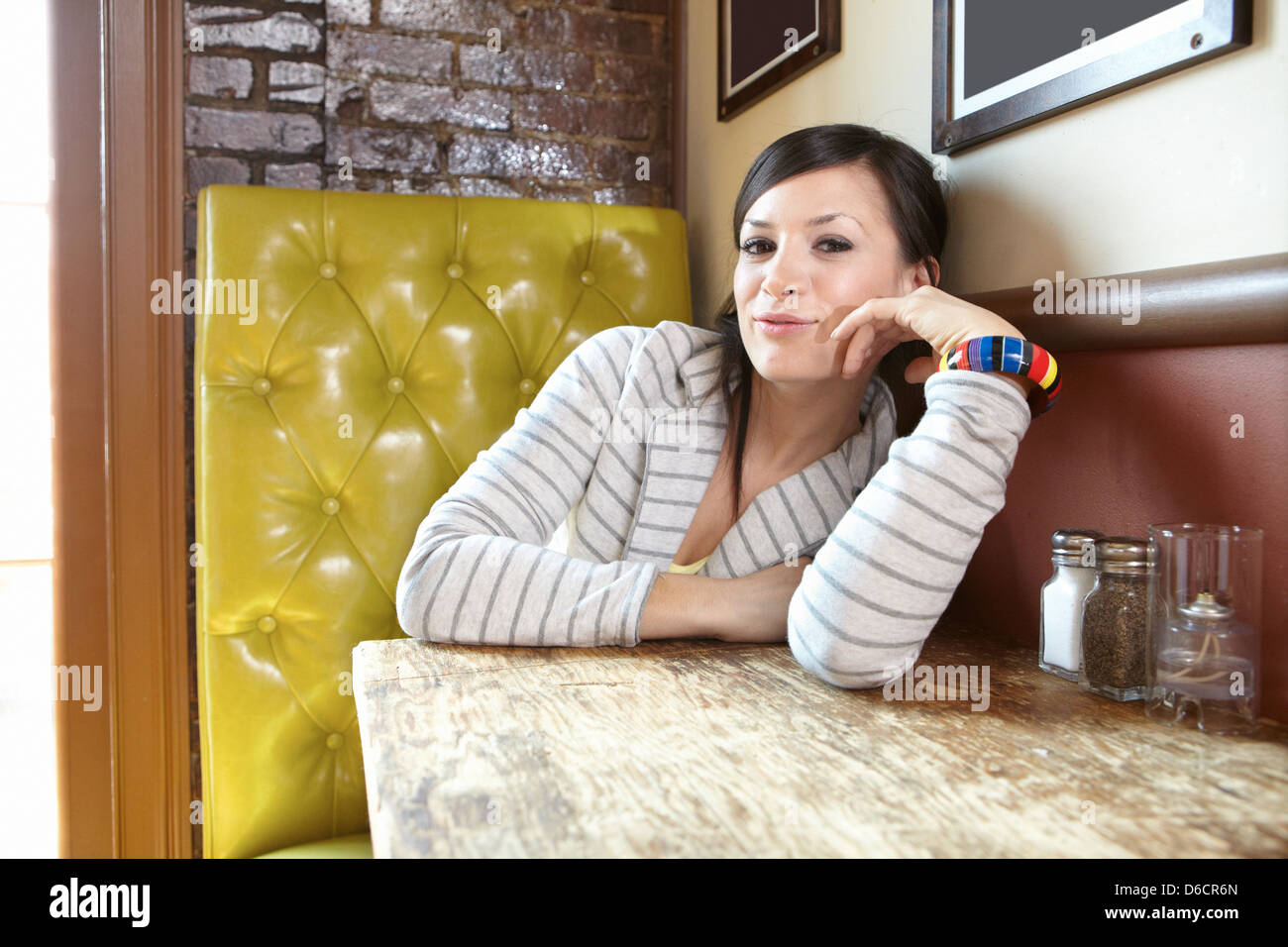 Girl leaning on table inside restaurant Stock Photo - Alamy