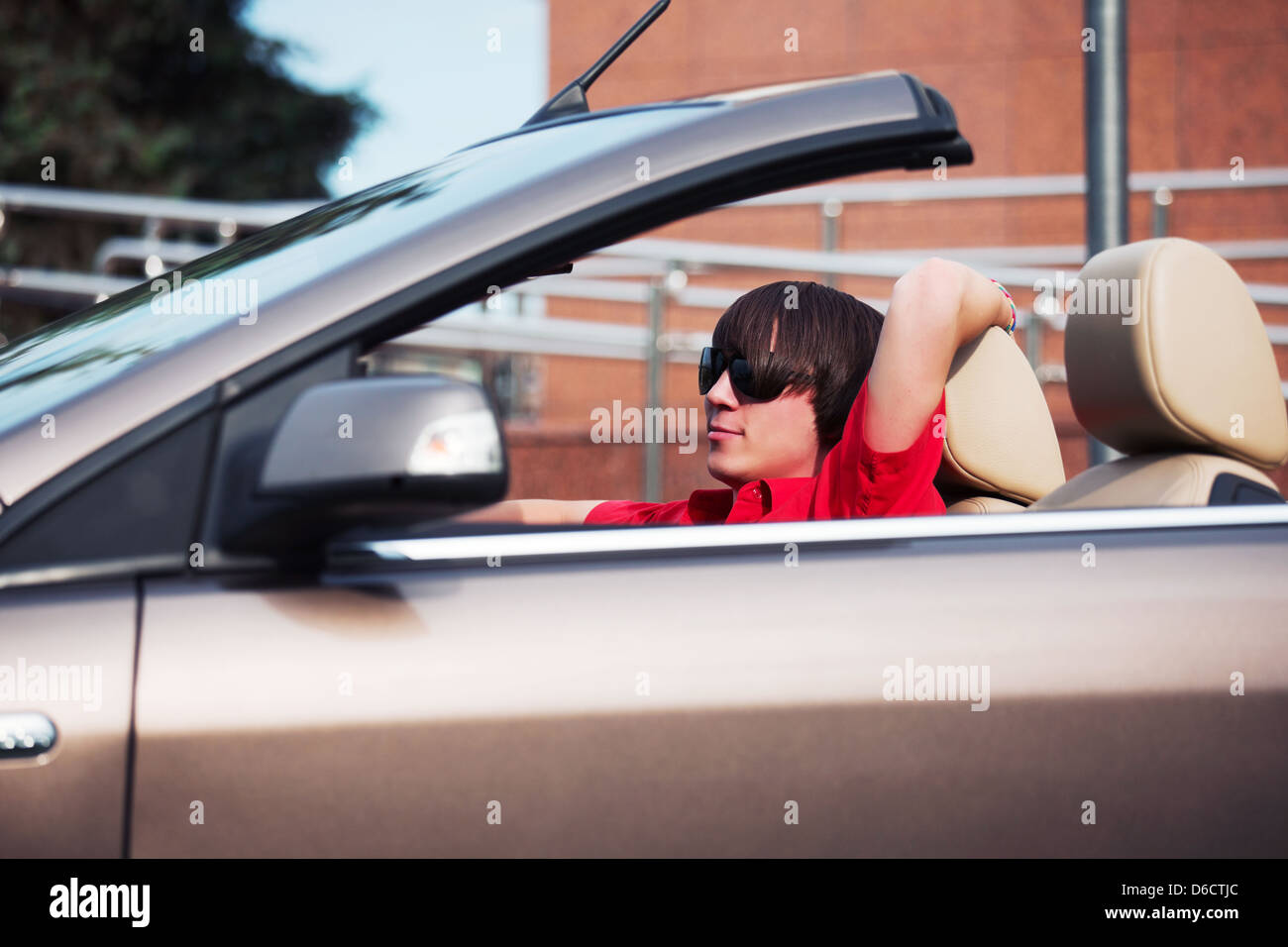 Young man driving a convertible car Stock Photo - Alamy