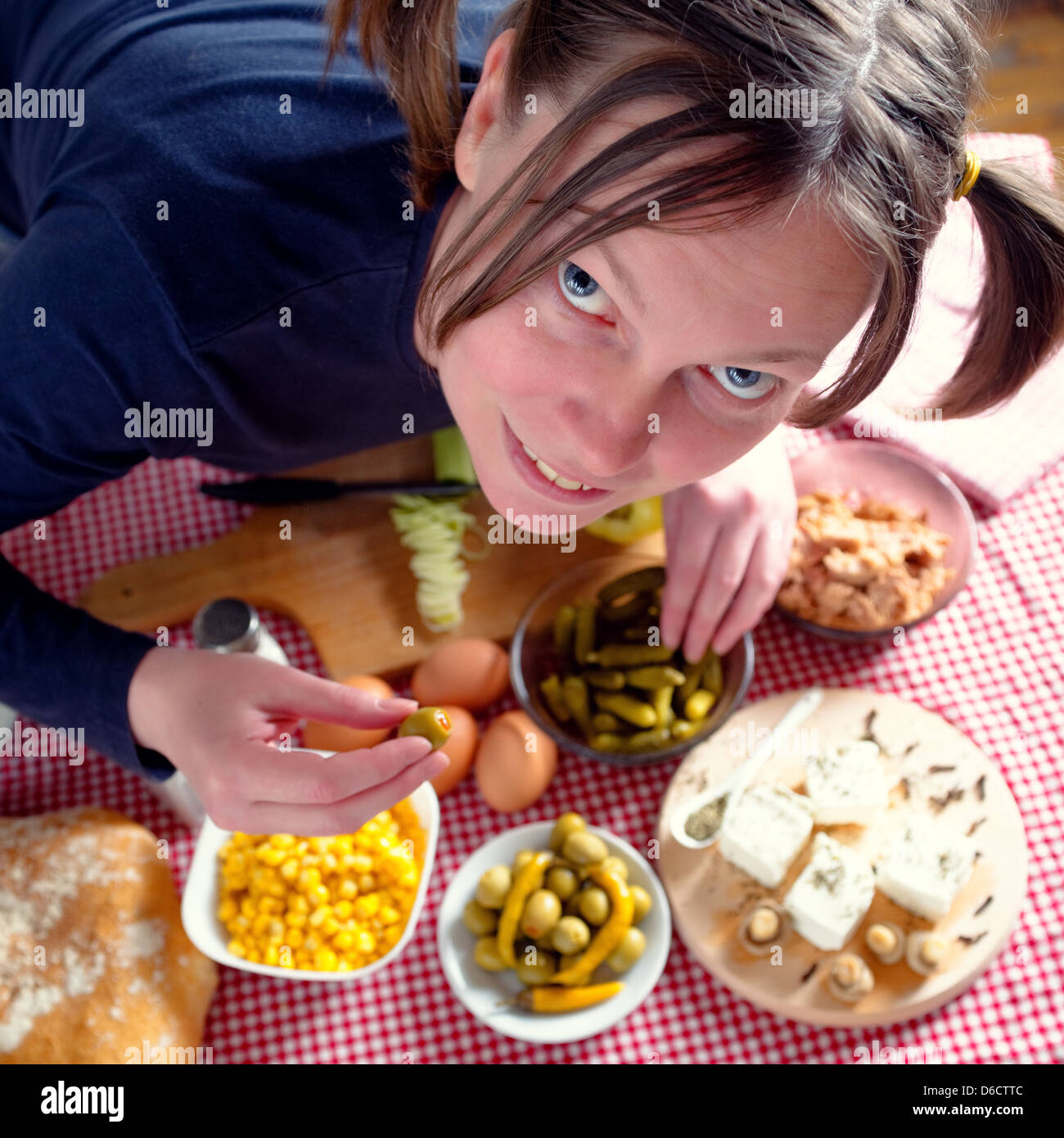 Woman eating olive. Beautiful smiling woman with pigtails eating olives ...