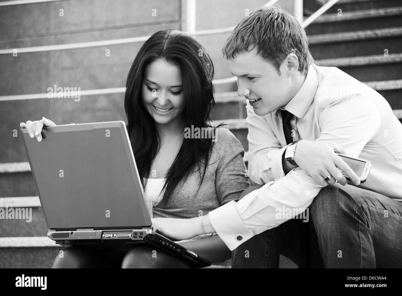 Young business couple using laptop Stock Photo - Alamy