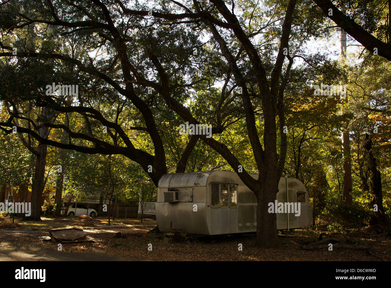 A mobile home parked between two trees in an American suburban ...