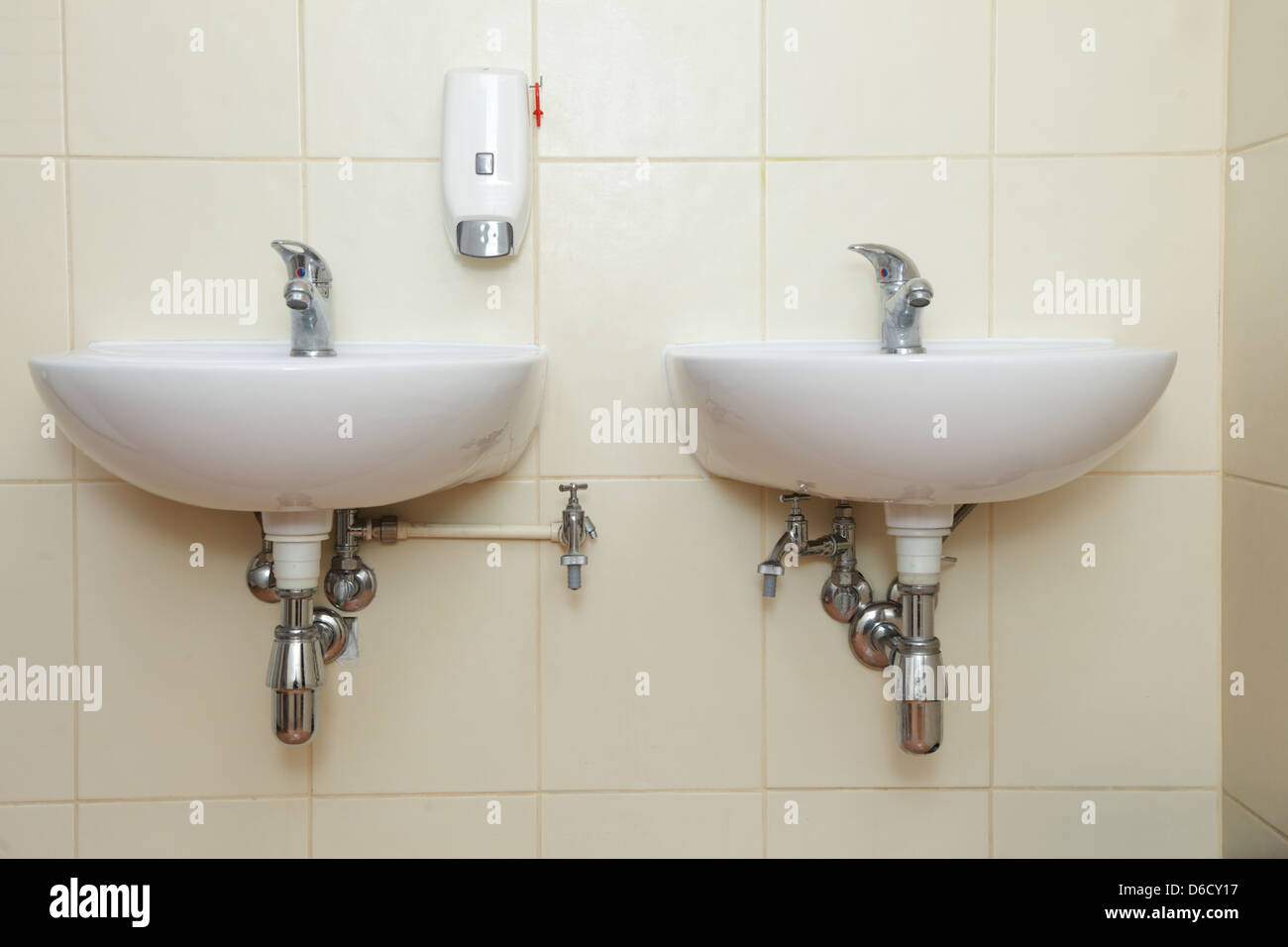 Two white sinks and liquid soap in public toilet Stock Photo - Alamy