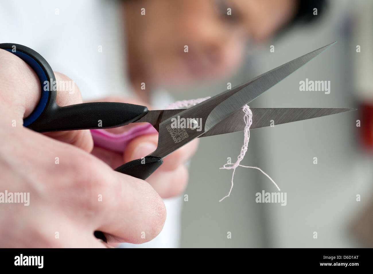 Berlin, Germany, Scissors cut by a thread Stock Photo - Alamy