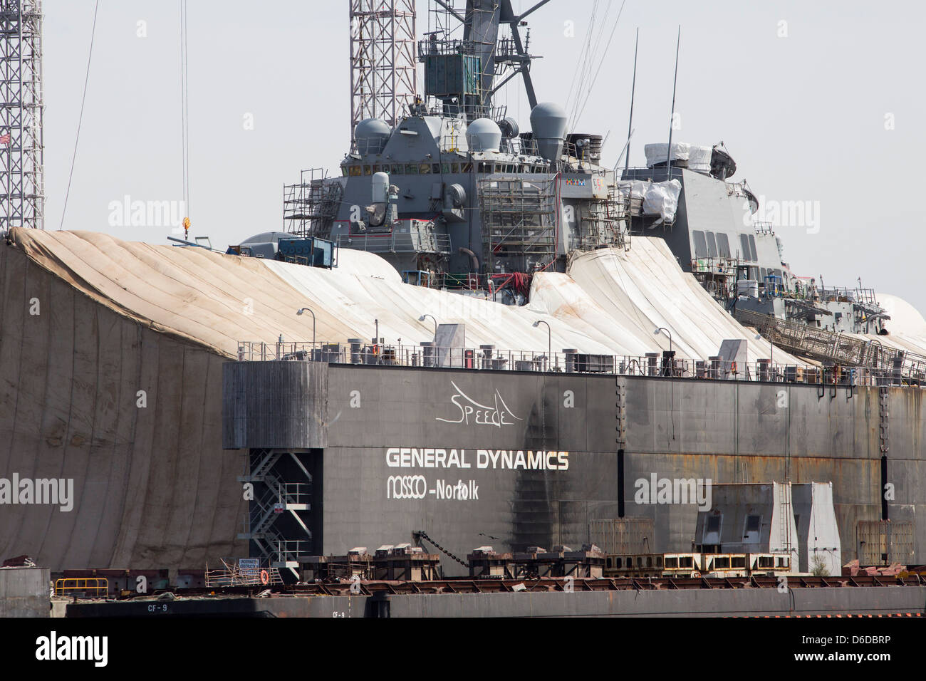 An Arleigh Burke class destroyer can be seen in a repair dry dock at ...