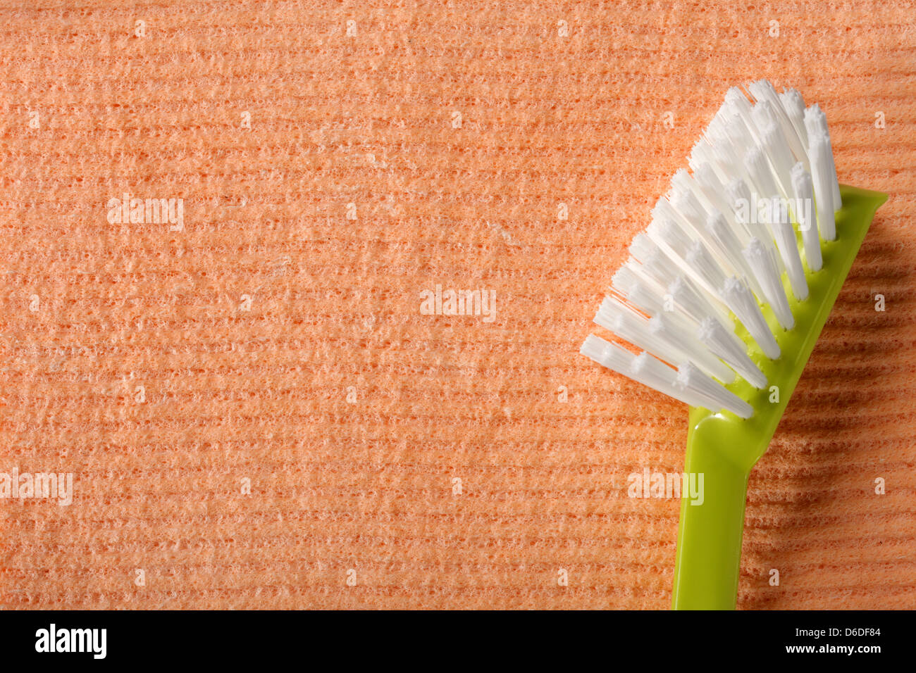 Orange sponge background and cleaning brush Stock Photo - Alamy