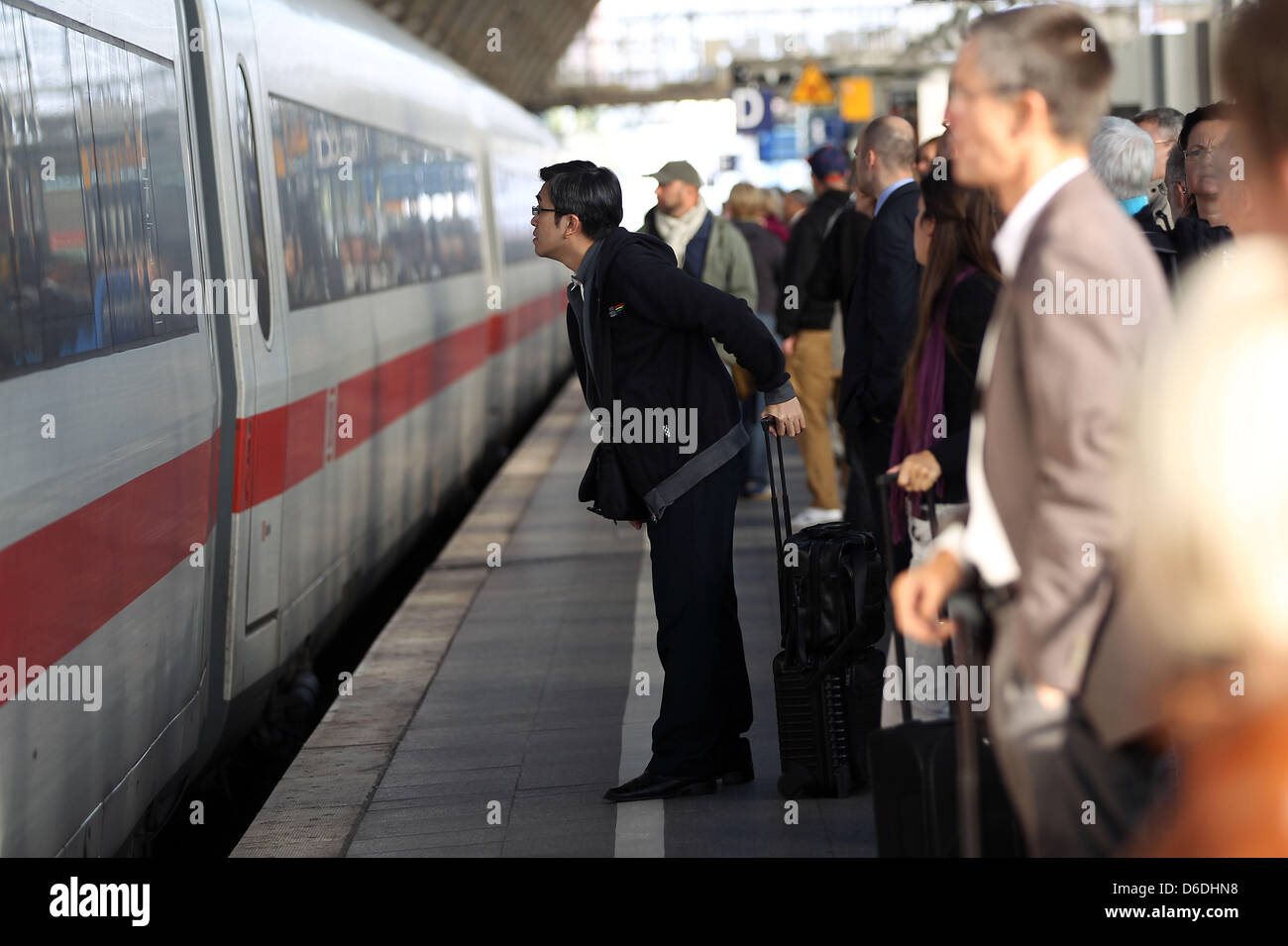 Passengers wait for a train of the Deutsche Bahn (German Rail) at a ...