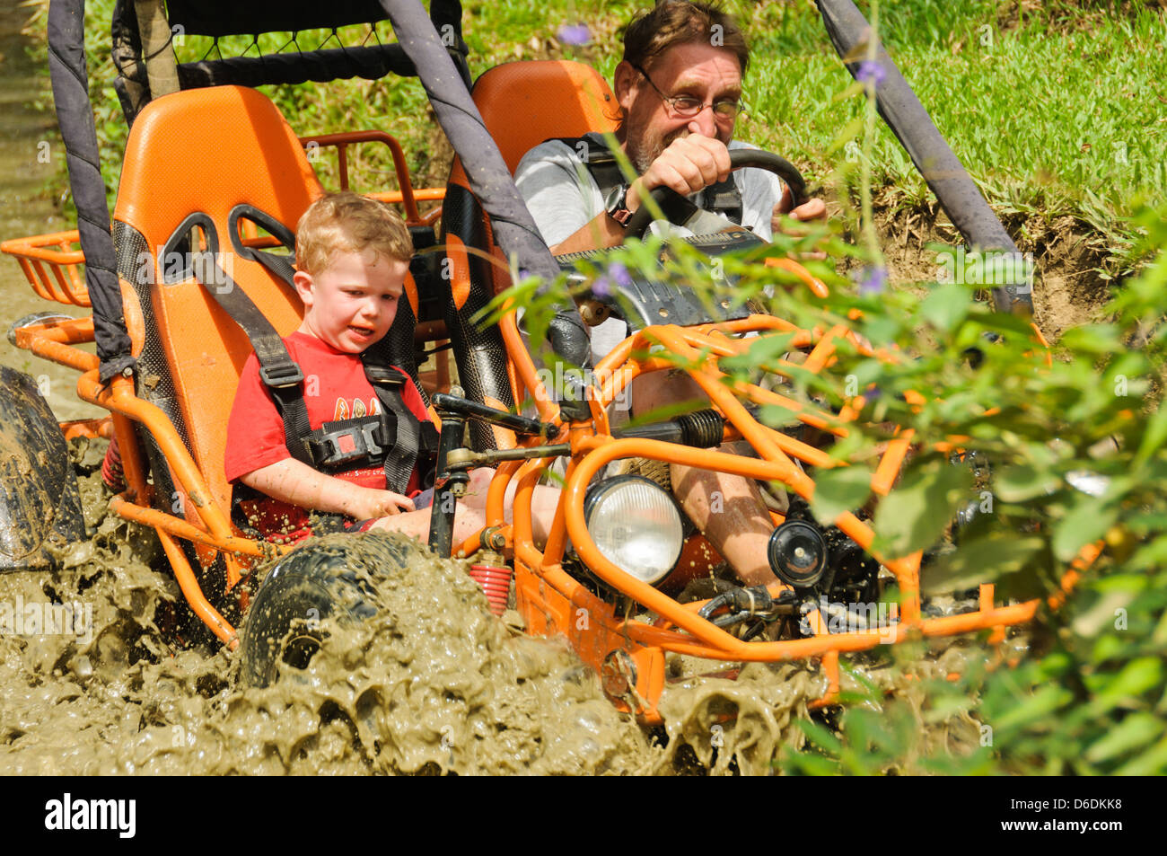 Father and son racing buggy driving muddy race track Adventure Park ...