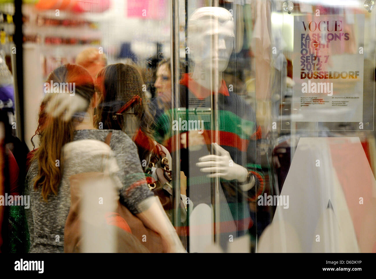 Customers look at fashion inside a store during the commercial event ...