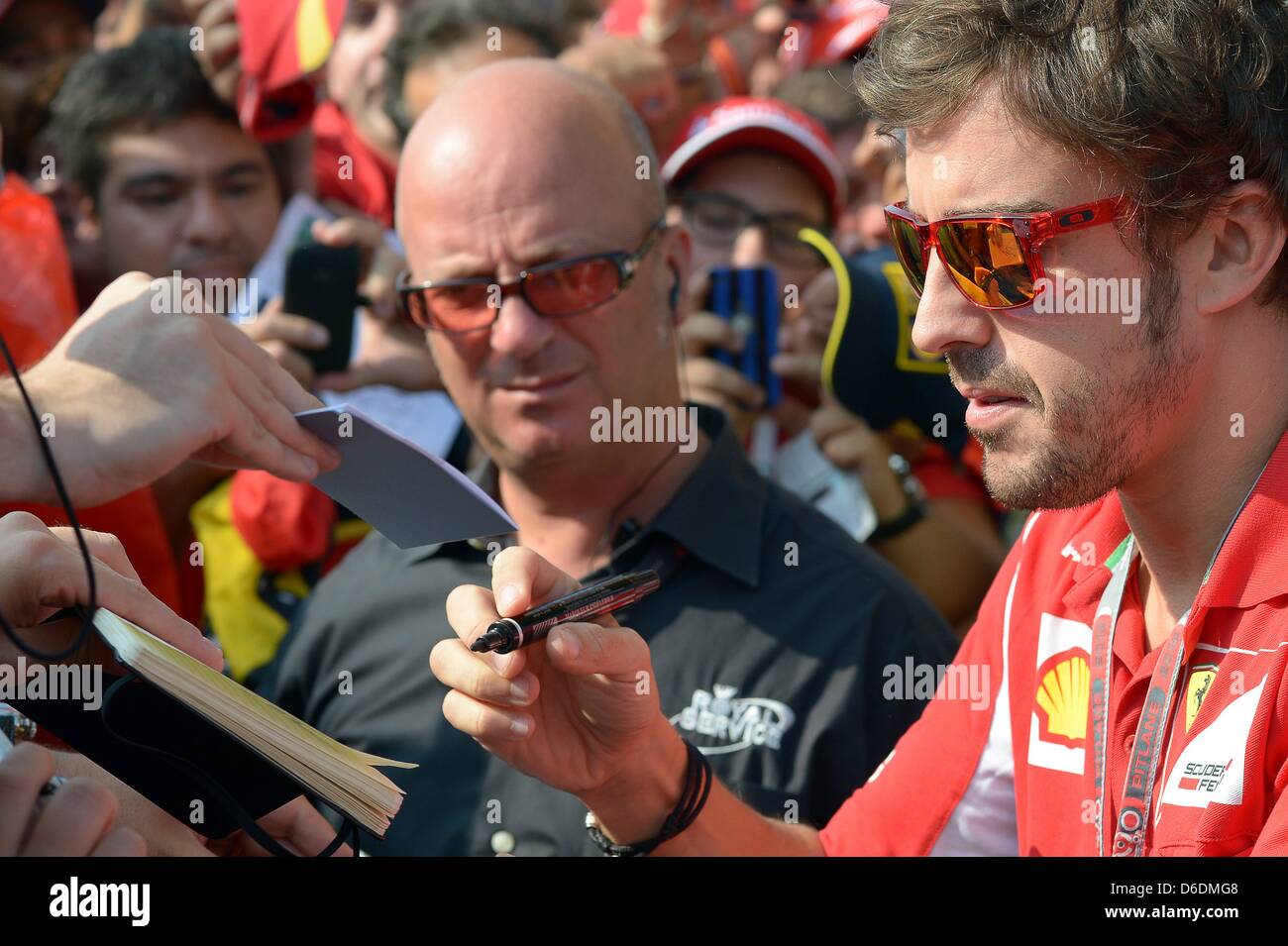 Spanish Formula One driver Fernando Alonso of Ferrari signs autographs ...