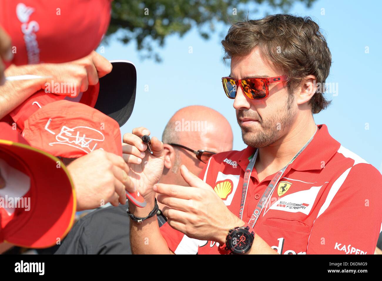 Spanish Formula One driver Fernando Alonso of Ferrari signs autographs ...
