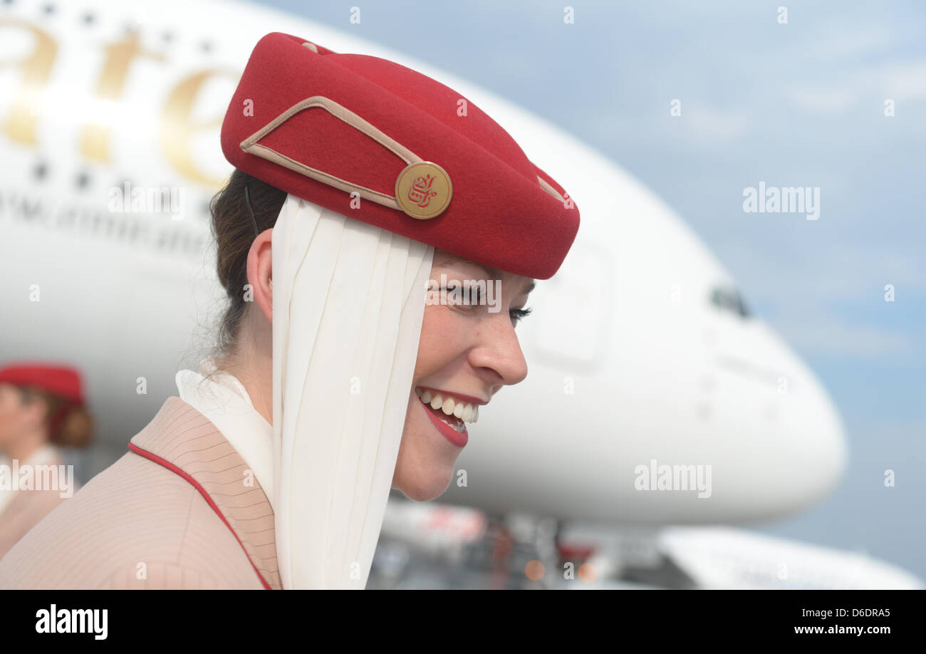An Emirates airline flight assistant smiles in front of an Airbus A380 ...