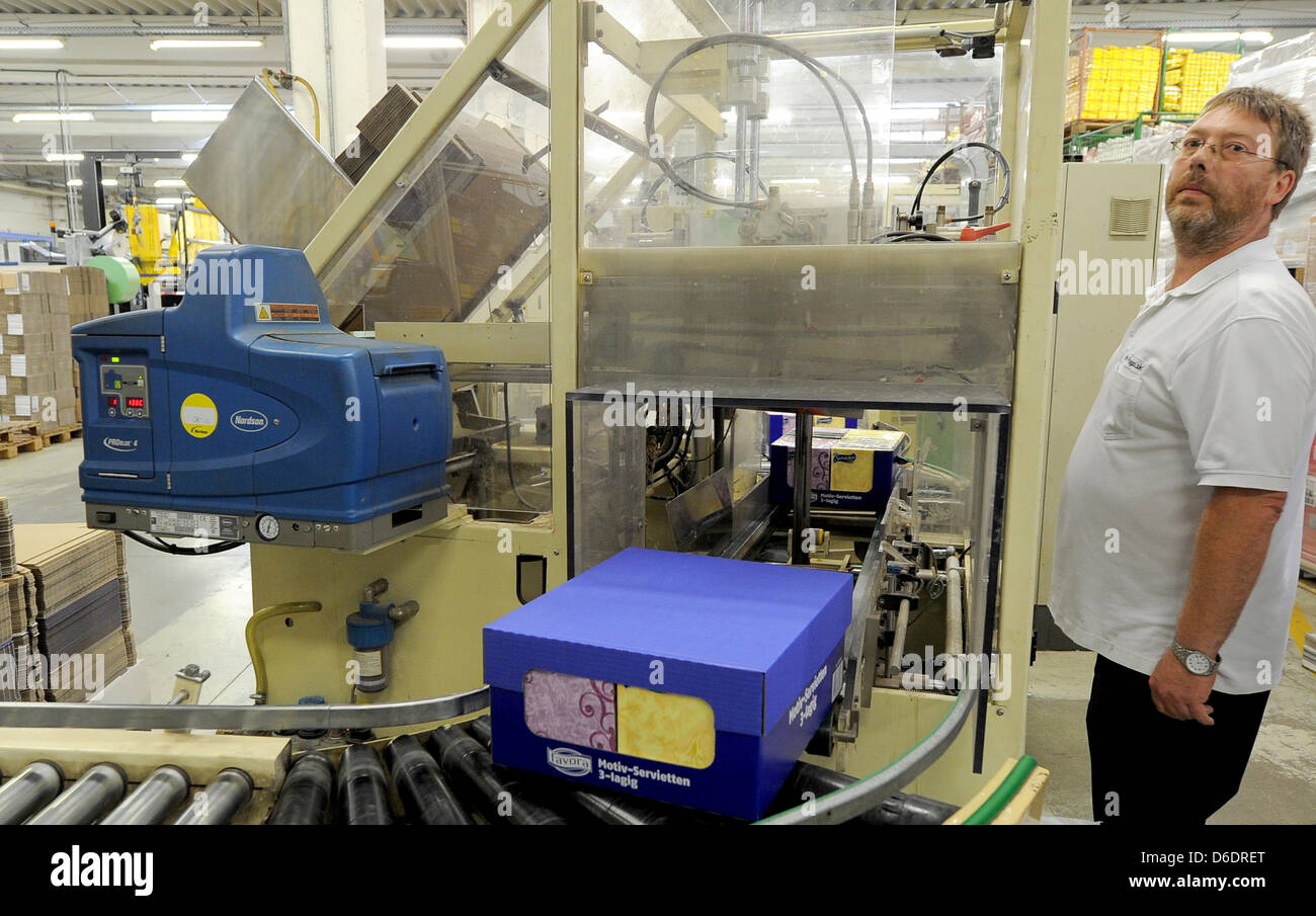 Boxes with various napkin designs run through the packaging system at ...