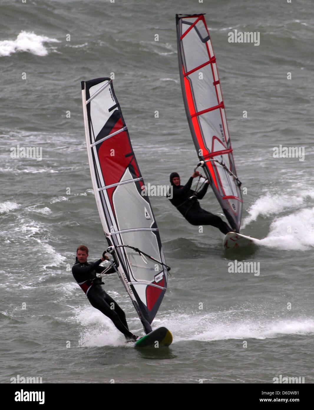 Surfers take advantage of the weather behind a jetty on the Baltic Sea ...
