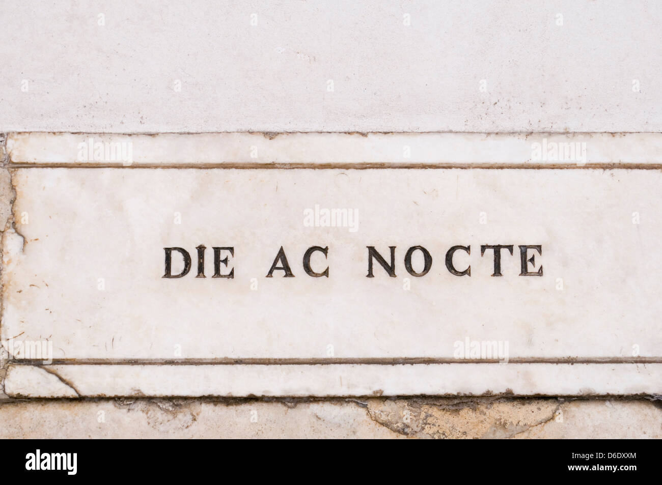 Latin script die ac nocte (day and night) carved on marble plaque on ...