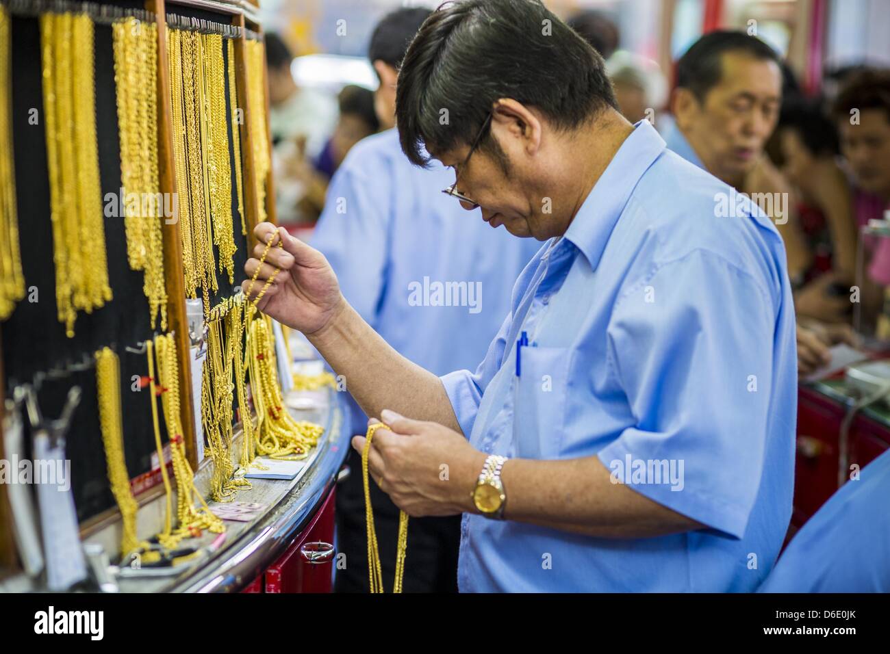 Bangkok, Thailand. April 17, 2013. A salesman in a gold shop in Bangkok ...