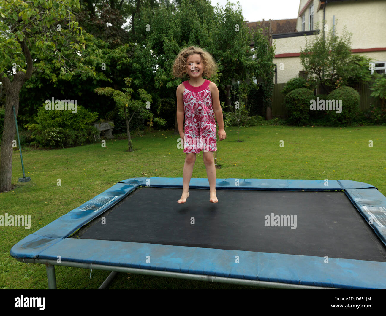 Girl Jumping On Trampoline In The Garden England Stock Photo - Alamy