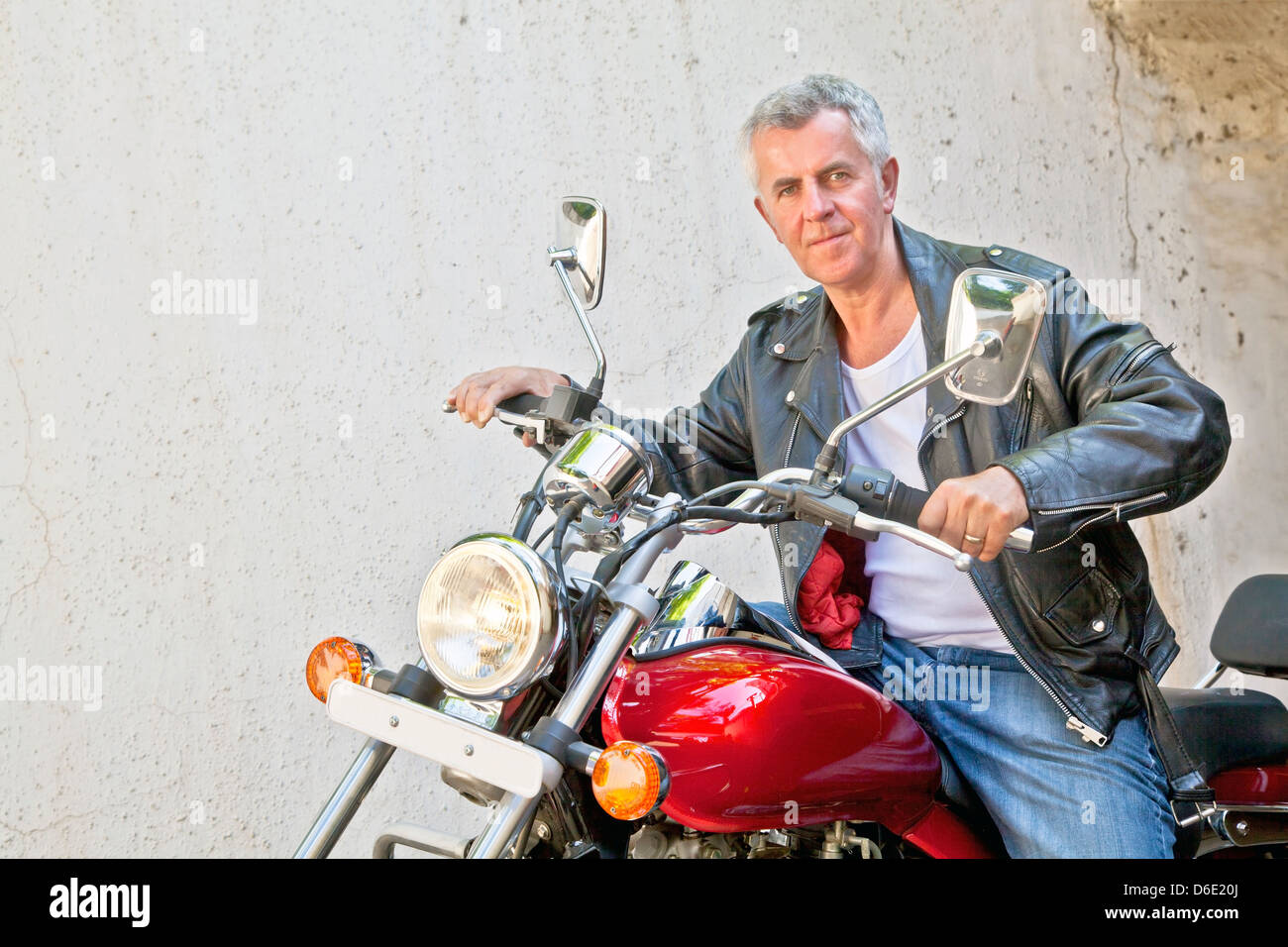 Horizontal caucasian motorcycle rider on a red cruiser with copy space ...