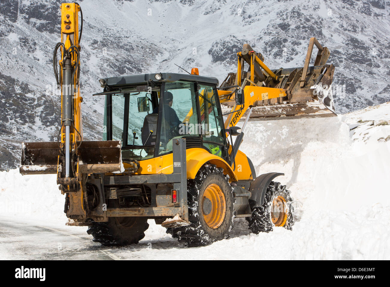 A JCB tries to clear a way through massive snow drifts blocking the ...