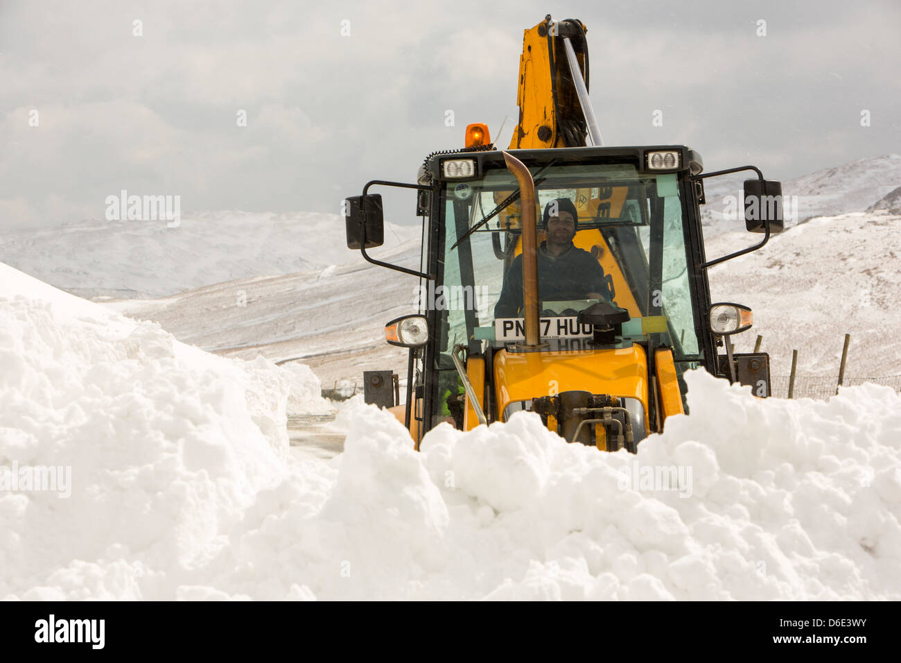 A JCB tries to clear a way through massive snow drifts blocking the ...