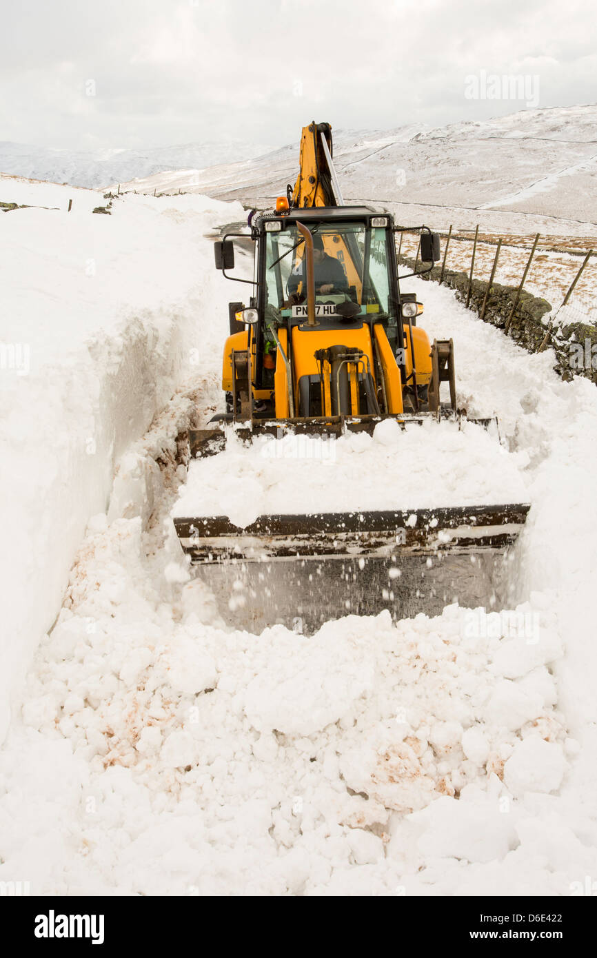 A JCB tries to clear a way through massive snow drifts blocking the ...
