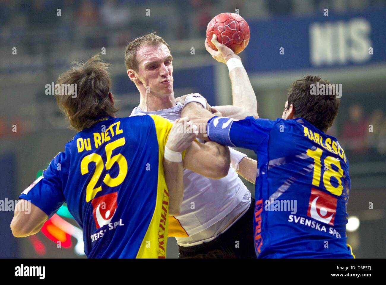 Germany's Holger Glandorf (C) is stopped by Sweden's Kim Ekdahl (L) and ...