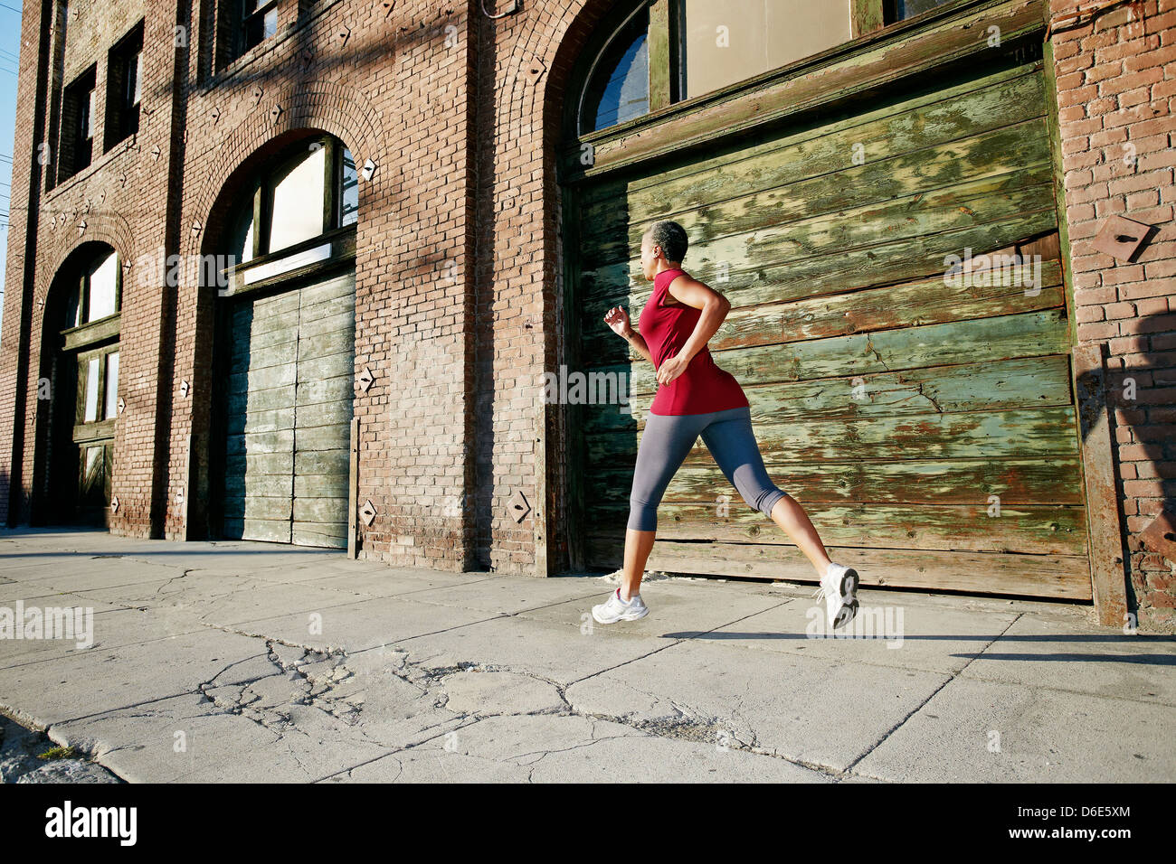 Black woman running on city street Stock Photo - Alamy