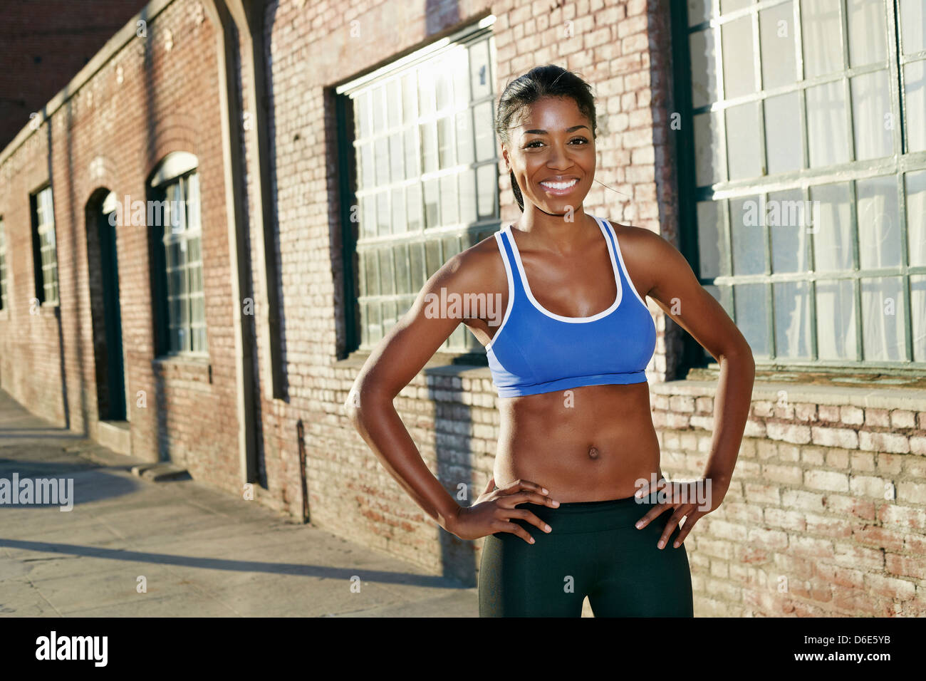 Black runner smiling on city street Stock Photo - Alamy