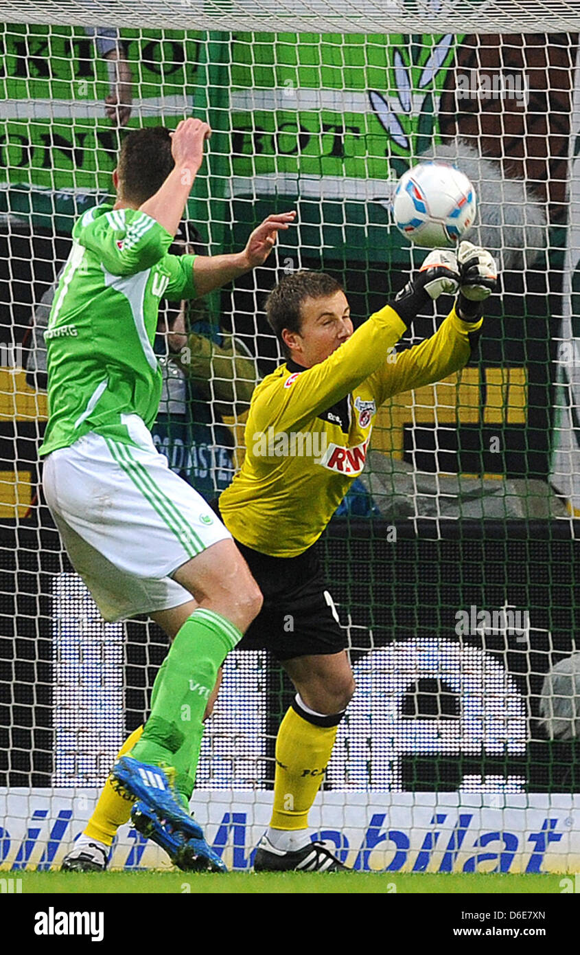 Cologne's goalkeeper Michael Rensing (R) deflects the ball during the ...