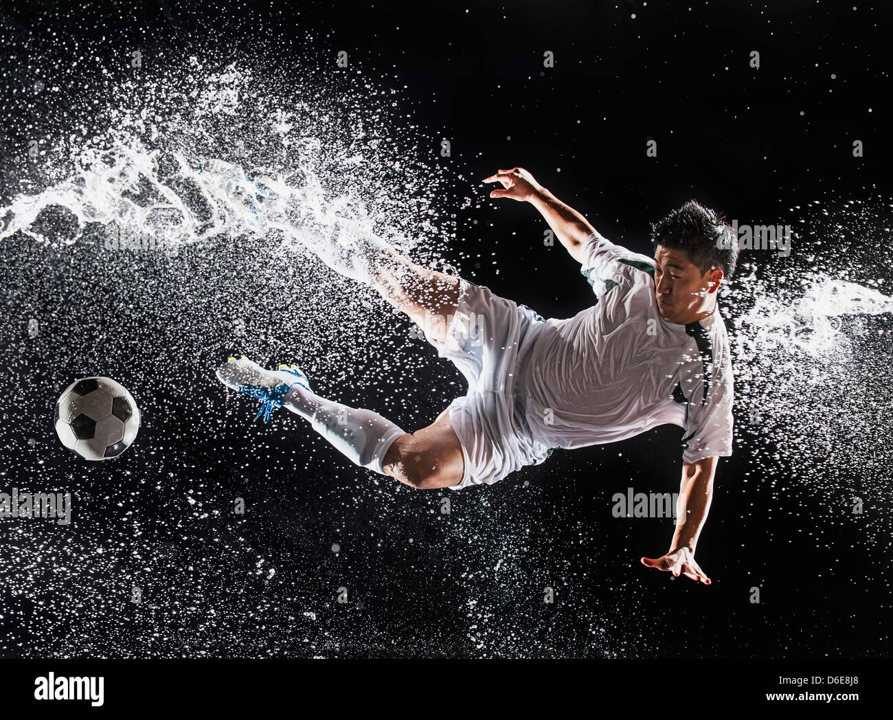Asian soccer player splashing in water Stock Photo - Alamy