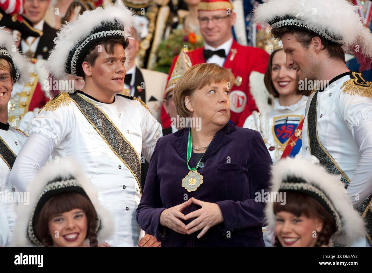German Chancellor Angela Merkel (M) stands between dancers of the ...