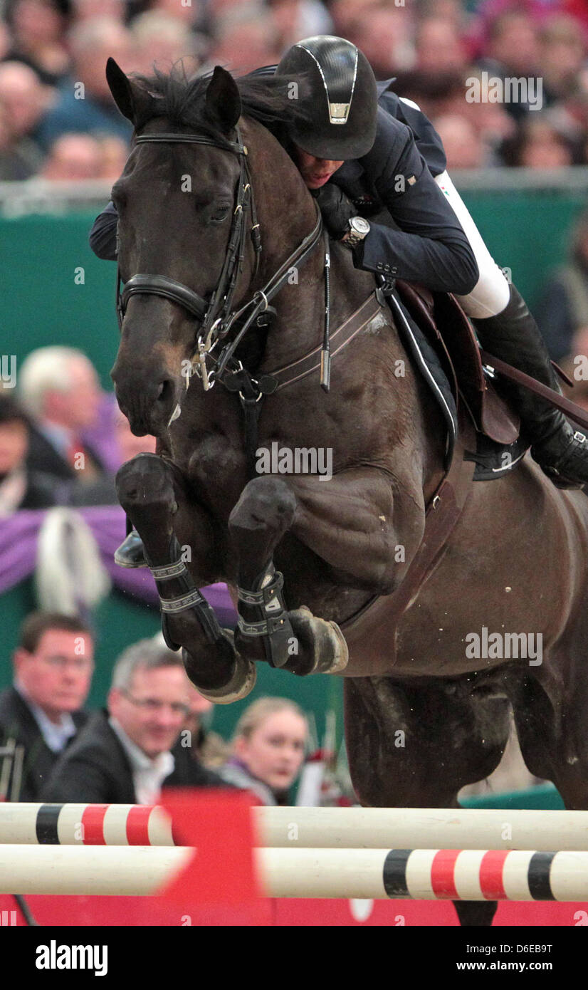 Belgian rider Kevin Staut jumps over a hurdle on Quarco de Kerambars at ...
