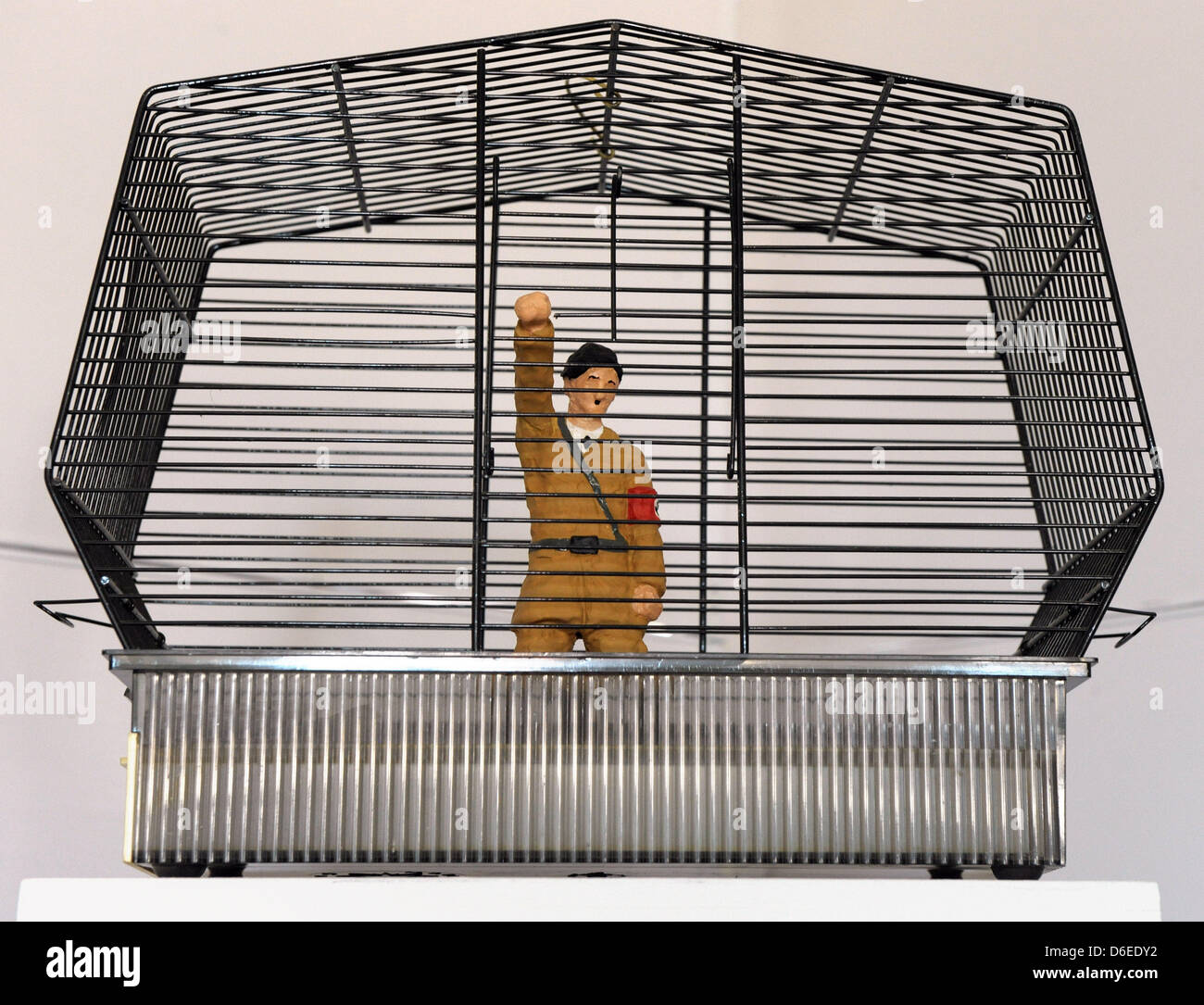 A small figurine of Hitler is situated in a bird cage and presented at ...