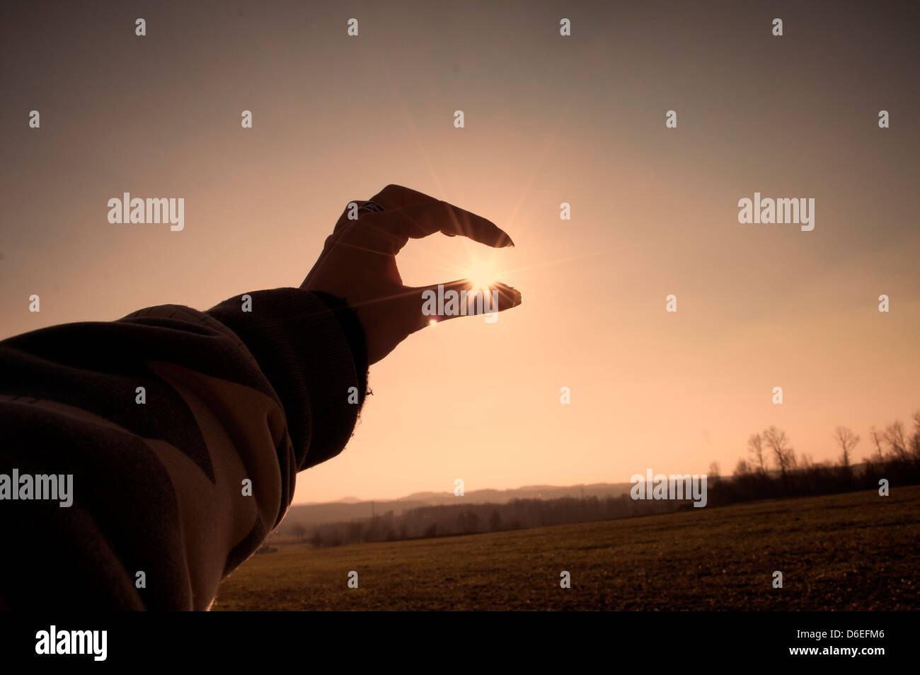 Sun between fingers Stock Photo - Alamy