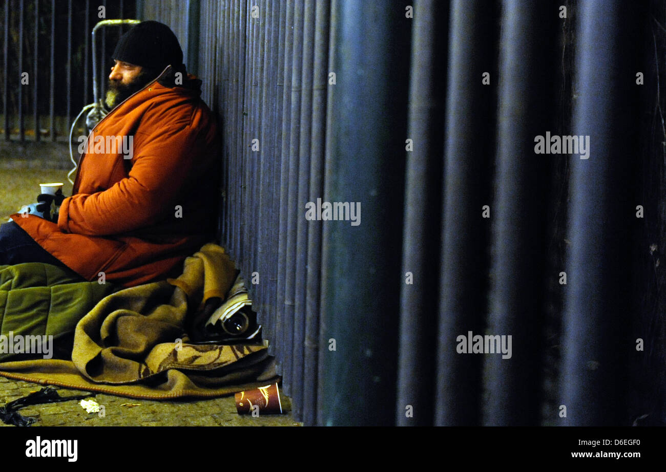 A homeless has a cup of tea received from a staff member of the German ...