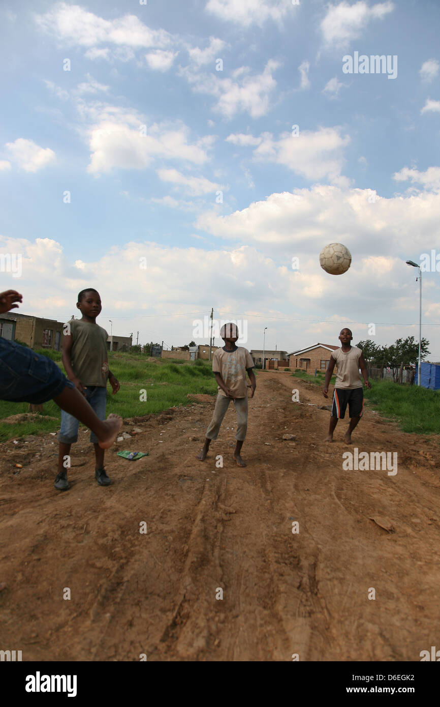 African boys play soccer in the dirt road in a small rural settl Stock ...