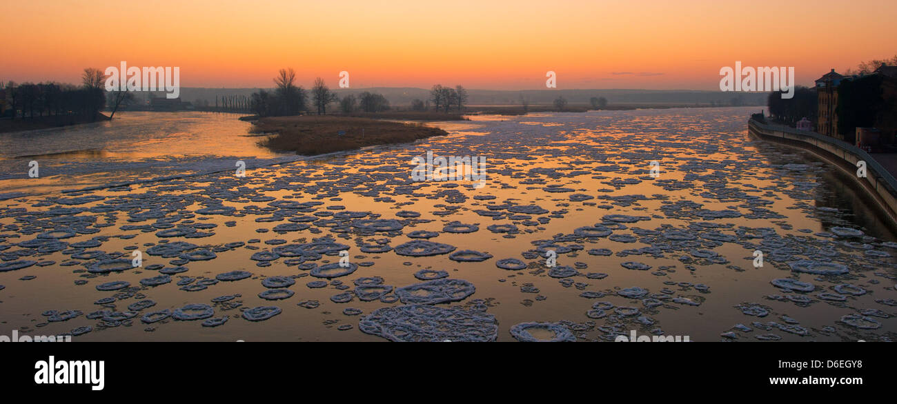 Ice floes float down the German-Polish border river Oder during sunrise ...