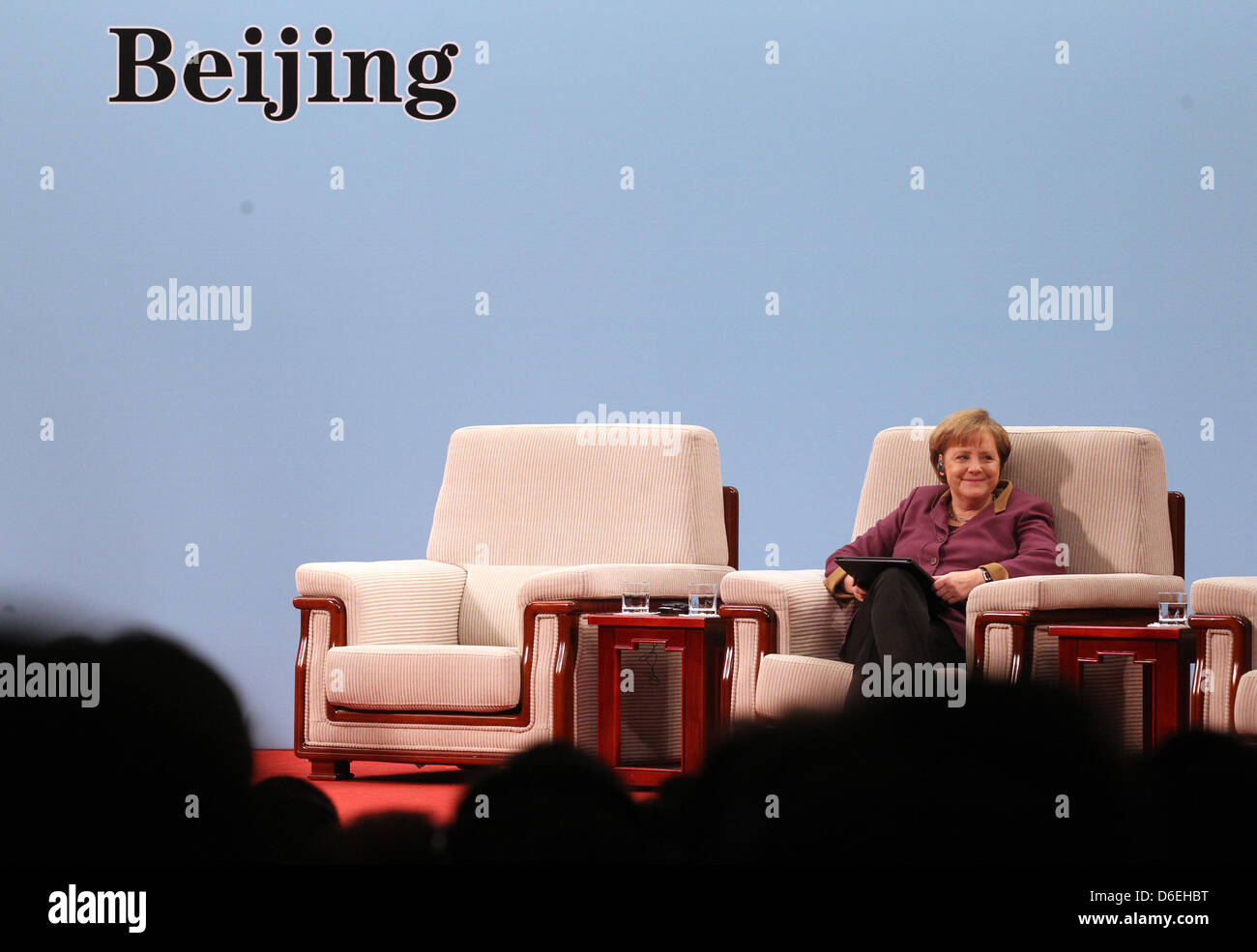 German Chancellor Angela Merkel sits in a chair on stage at the Chinese ...