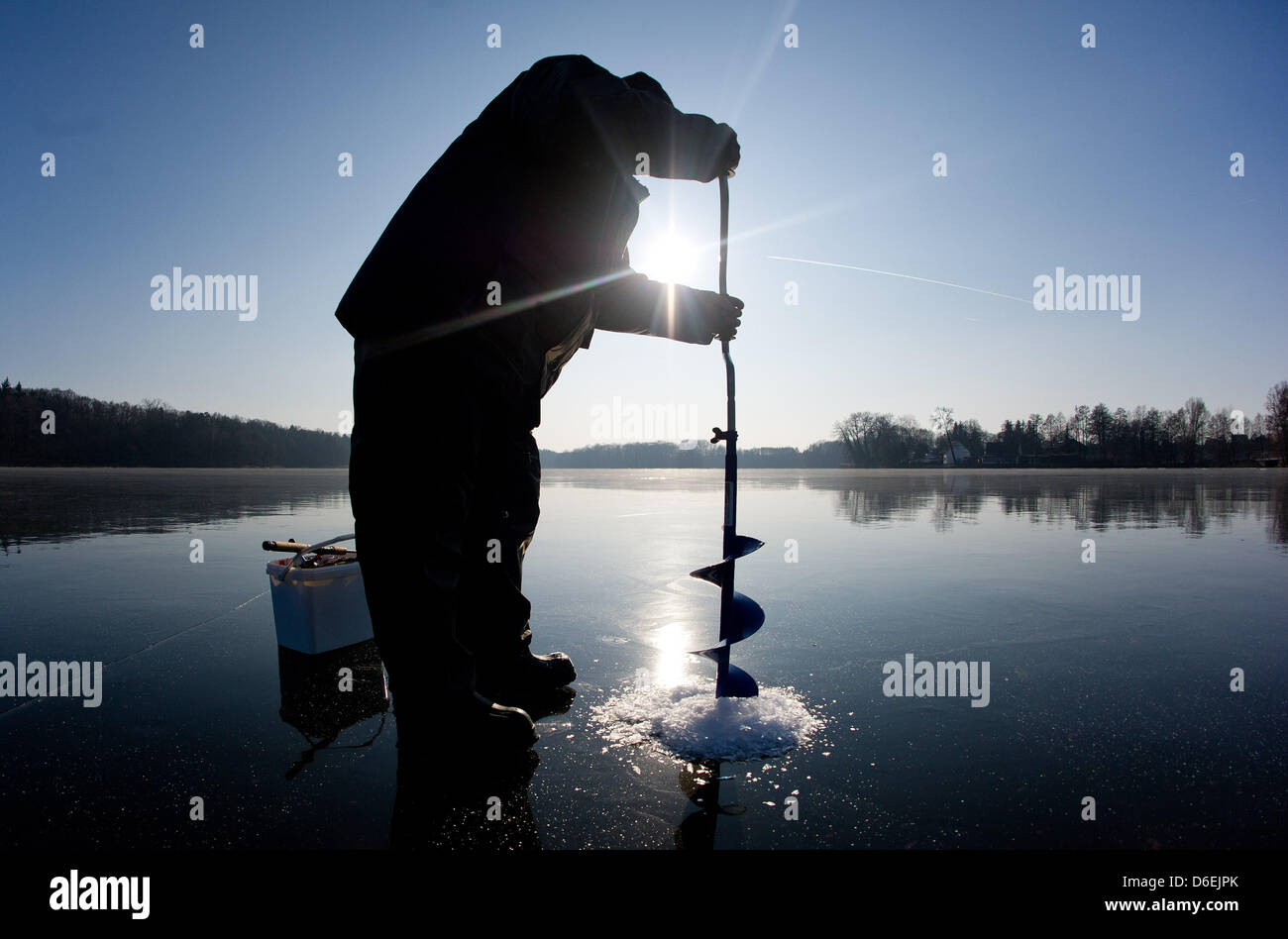 Ice fisher Olaf Berg drills a hole in the 15 centimeter thick ice on ...