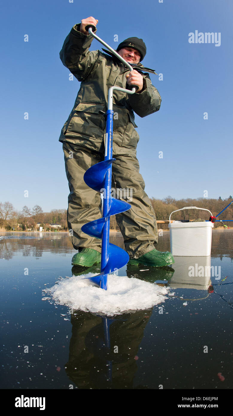 Ice fisher Olaf Berg drills a hole in the 15 centimeter thick ice on ...