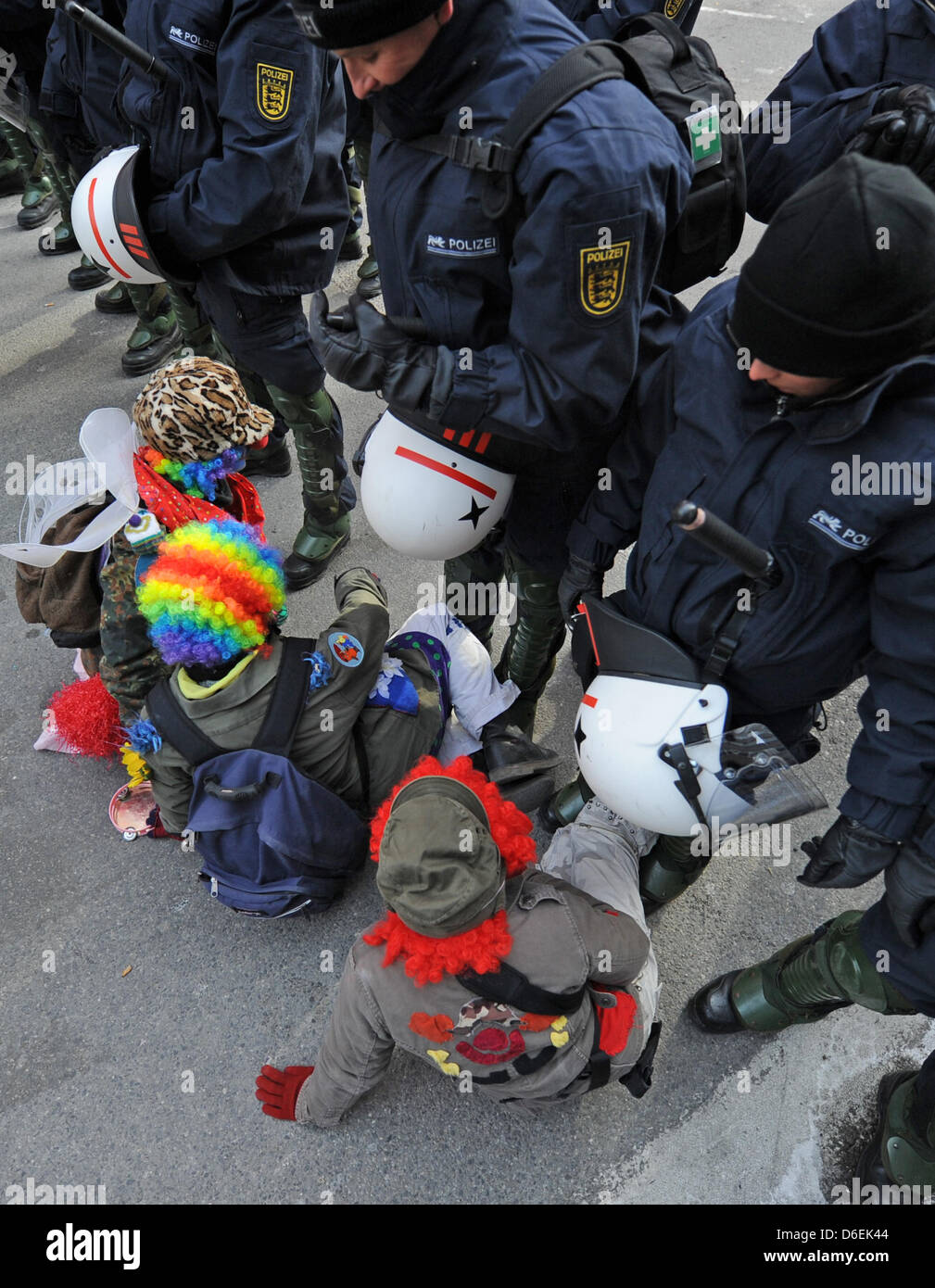 Protesters dress as clowns lie in front of police officers during a ...