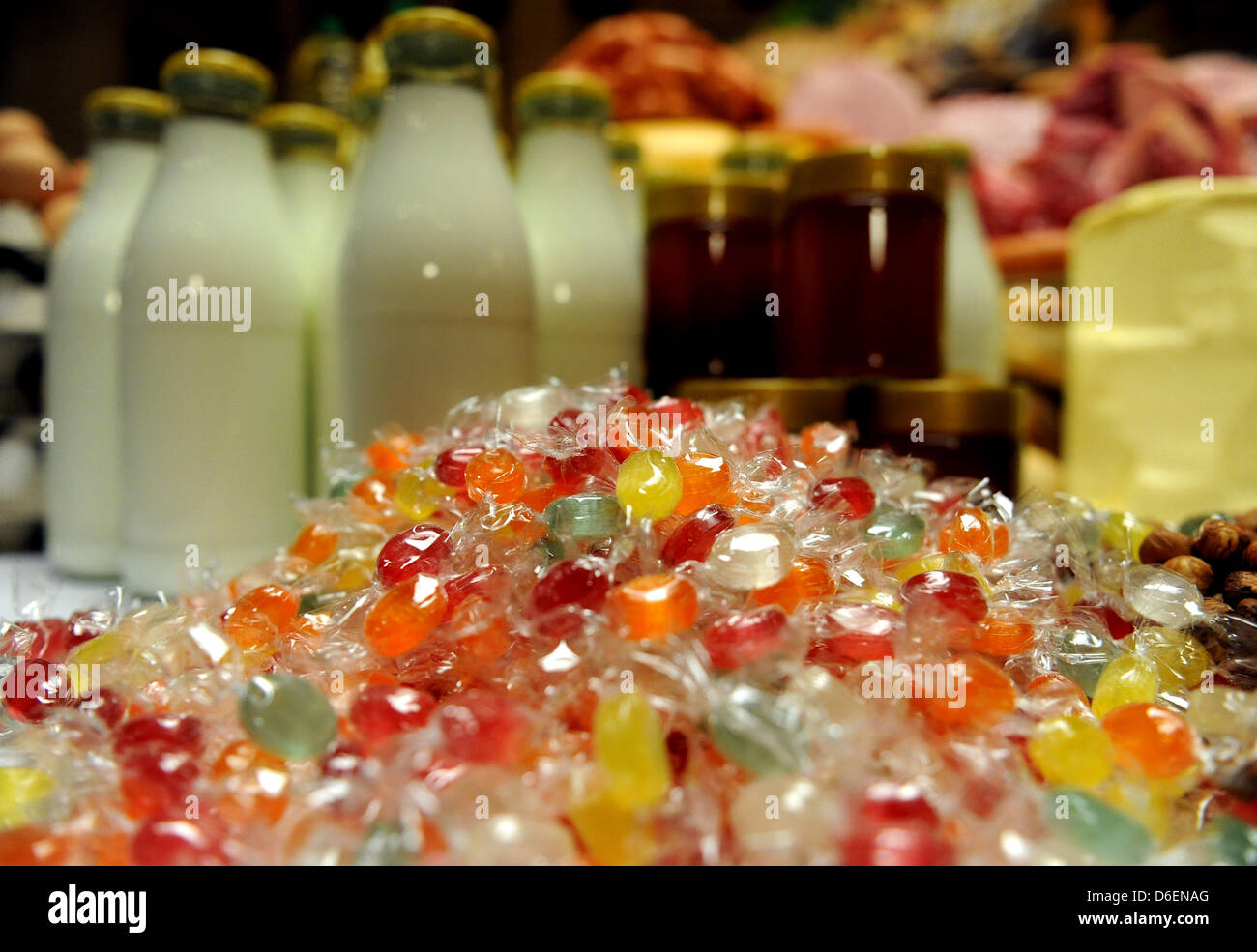Candy drops are set up in front of bottled milk and honey jars in ...