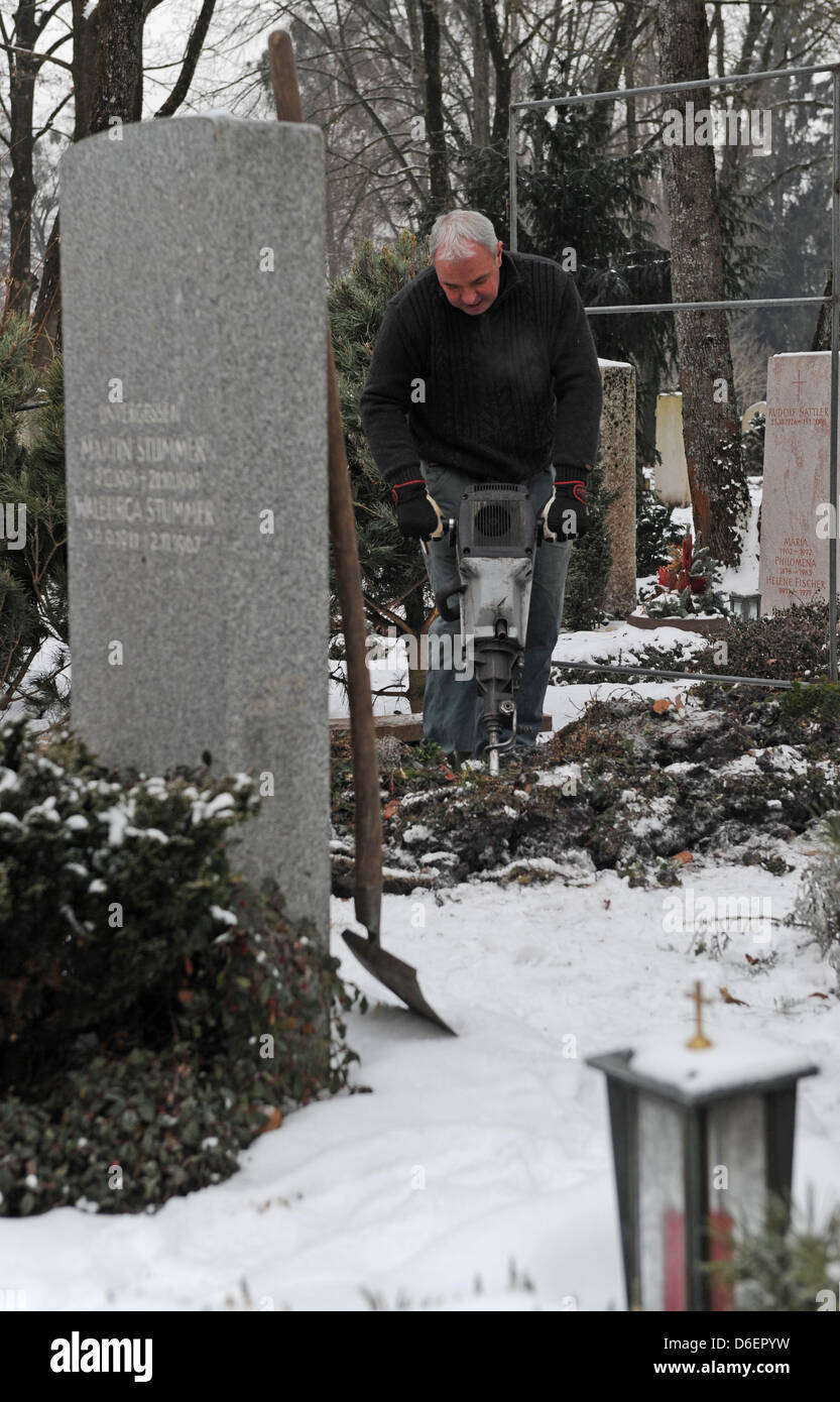 Gravedigger Josef Weiland tries to dig a grave with the help of an air ...