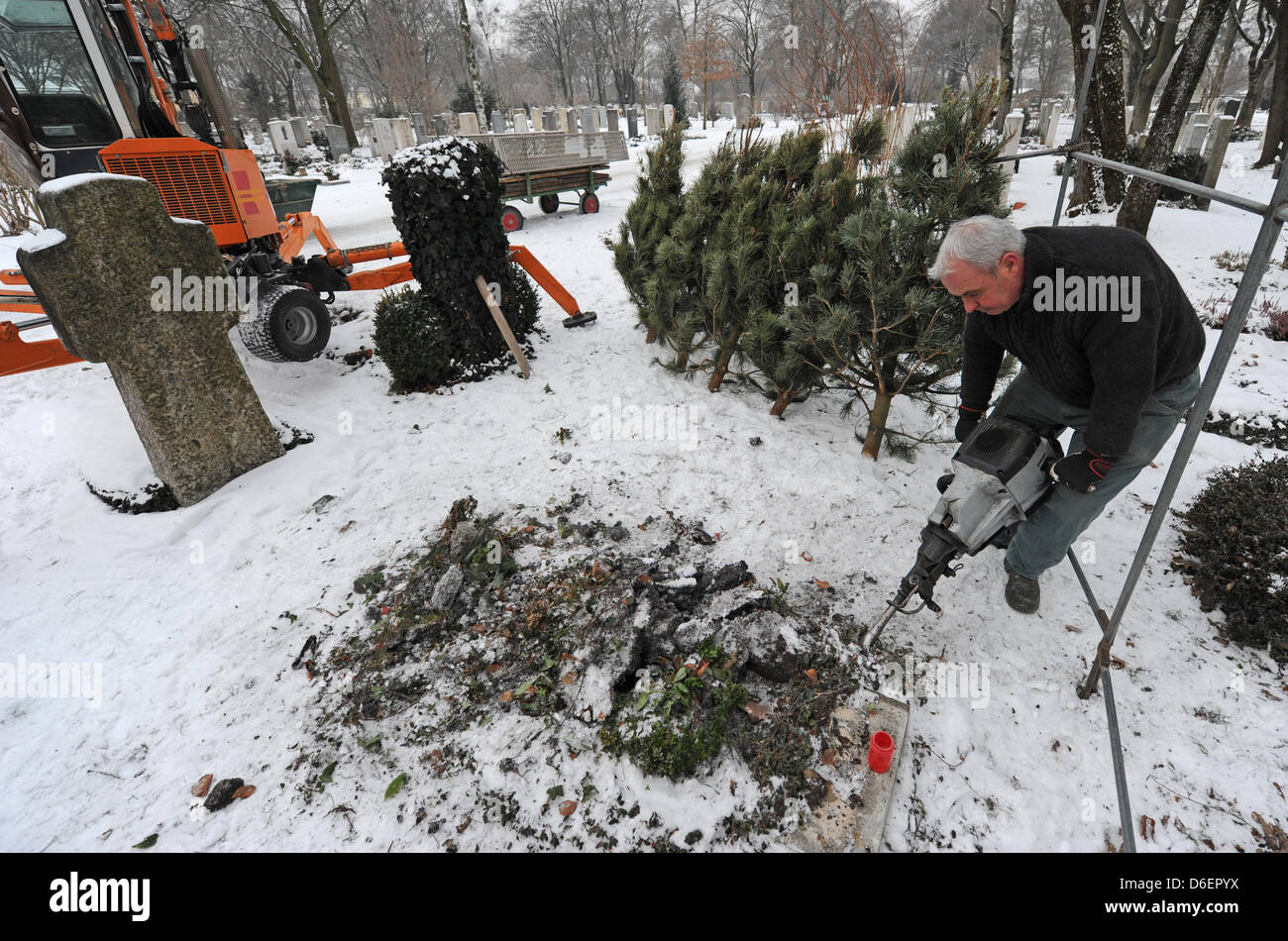Gravedigger Josef Weiland tries to dig a grave with the help of an air ...