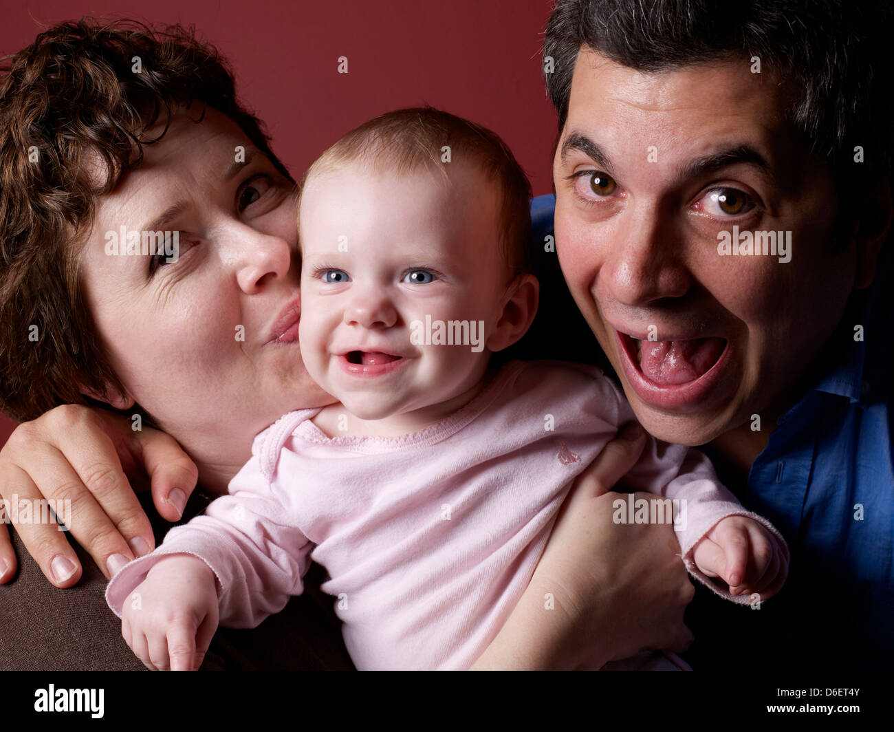 Parents smiling with baby Stock Photo - Alamy