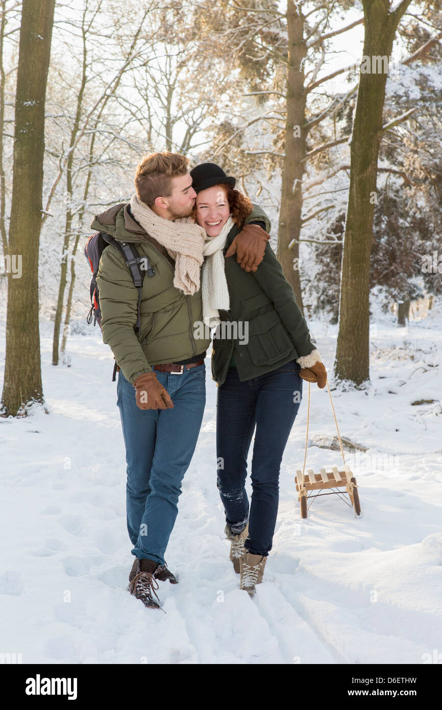 Caucasian couple pulling sled in snow Stock Photo - Alamy