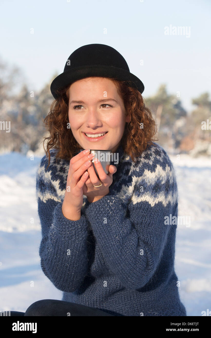 Caucasian woman drinking coffee in snow Stock Photo - Alamy