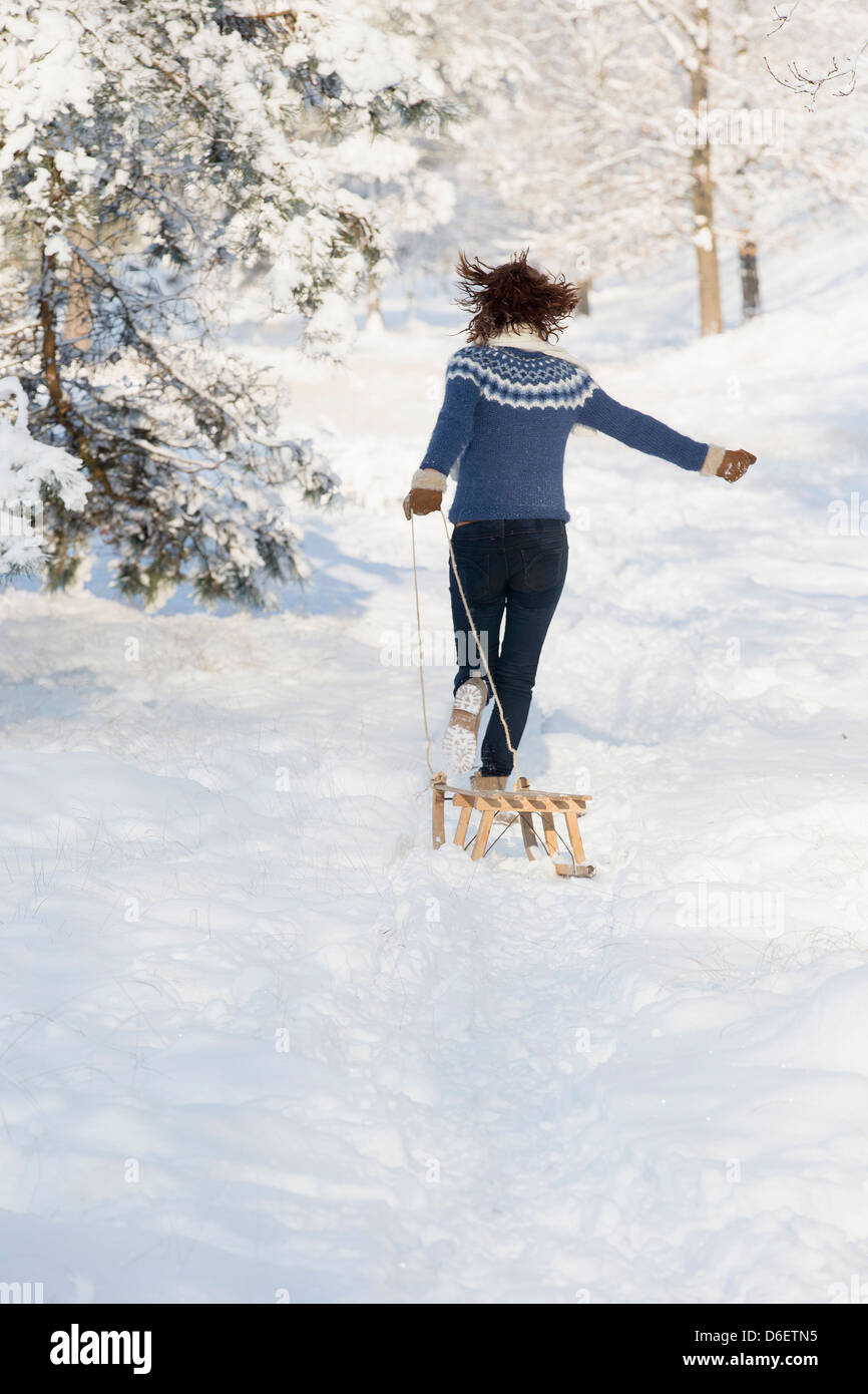 Caucasian woman pulling sled in snow Stock Photo - Alamy