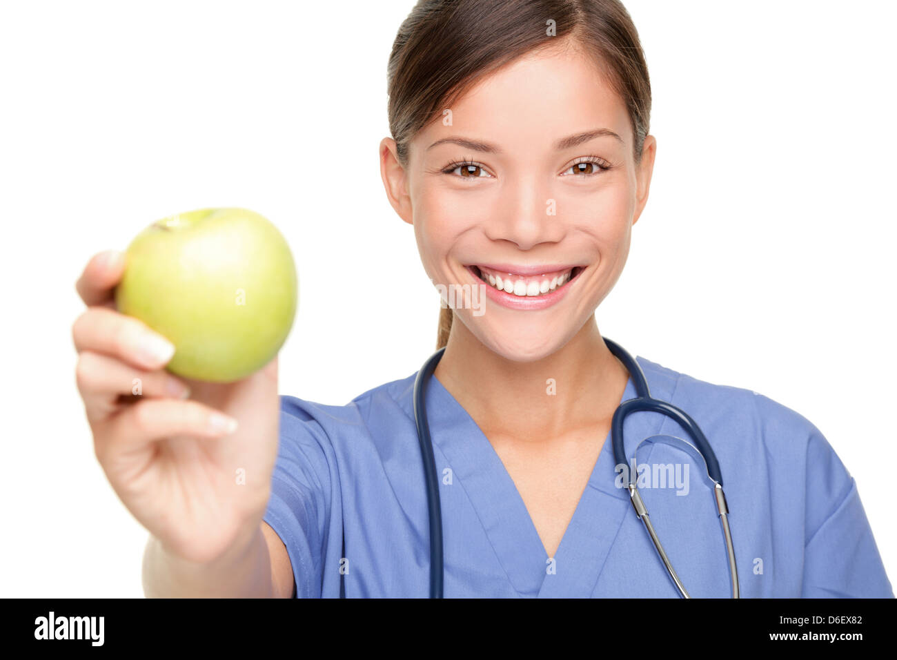Nurse or young doctor giving an apple smiling. Health care concept ...