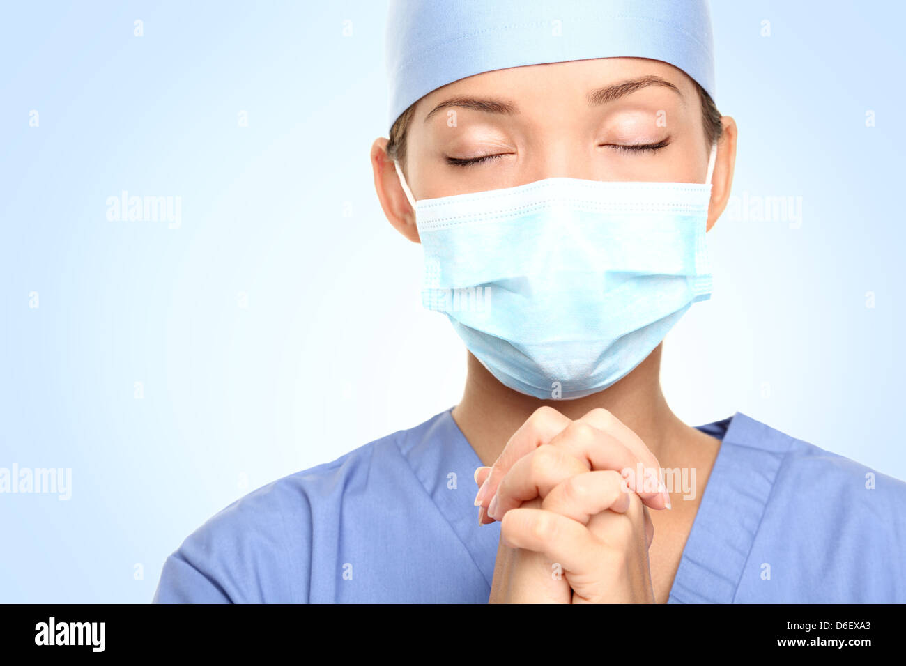 Doctor praying for help. Young woman medical doctor surgeon or nurse ...