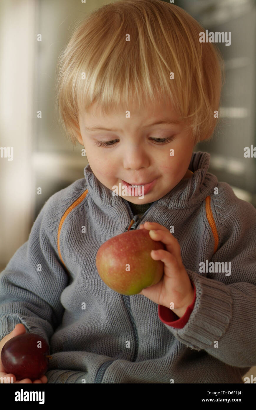 Boy with apple and plum Stock Photo - Alamy